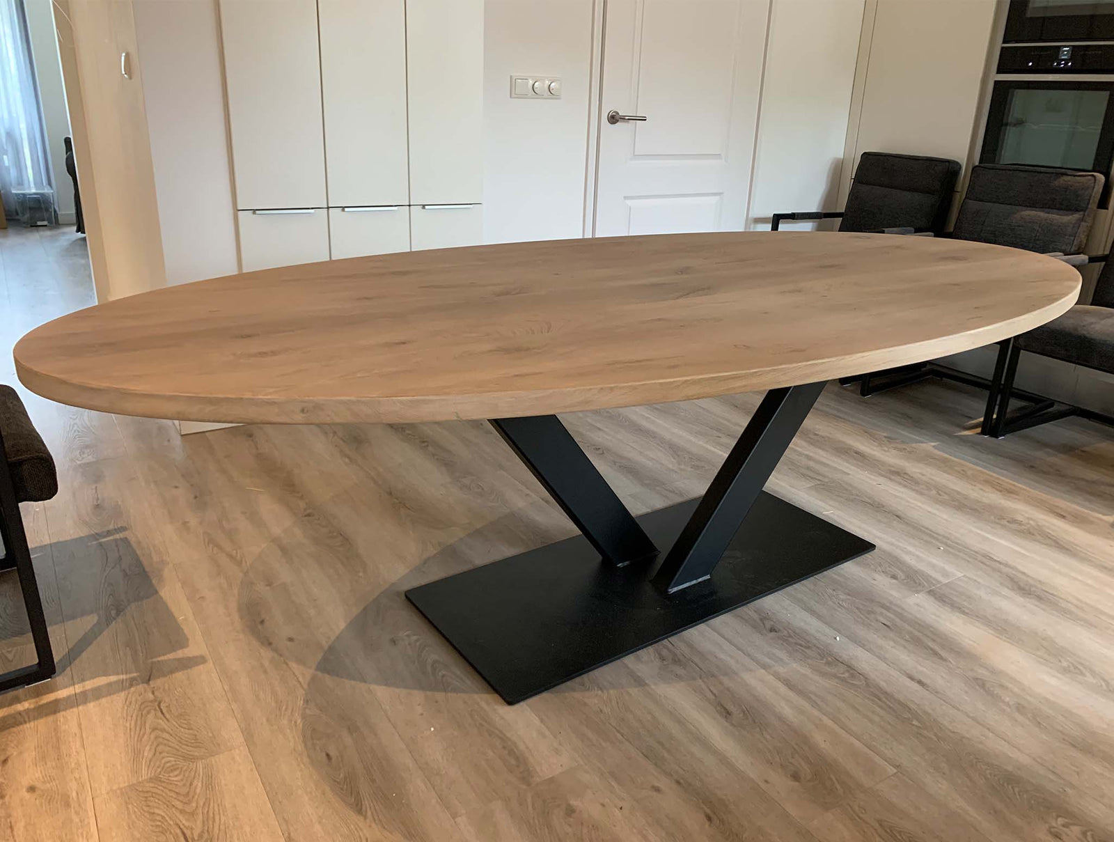 Deens ovale eettafel met houten trapezium poten